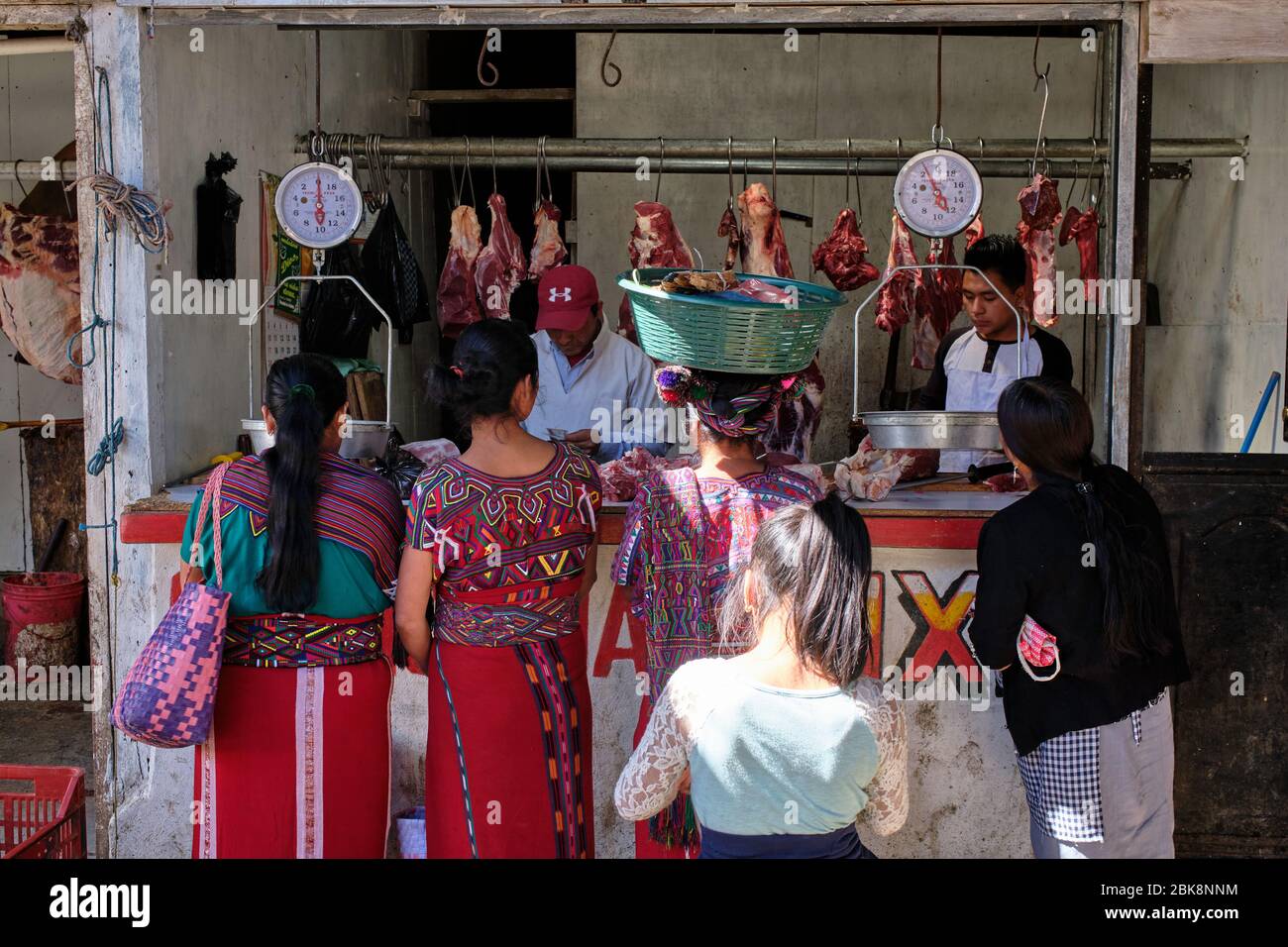Women dressed in the colorful costumes of the Ixil community buying ...