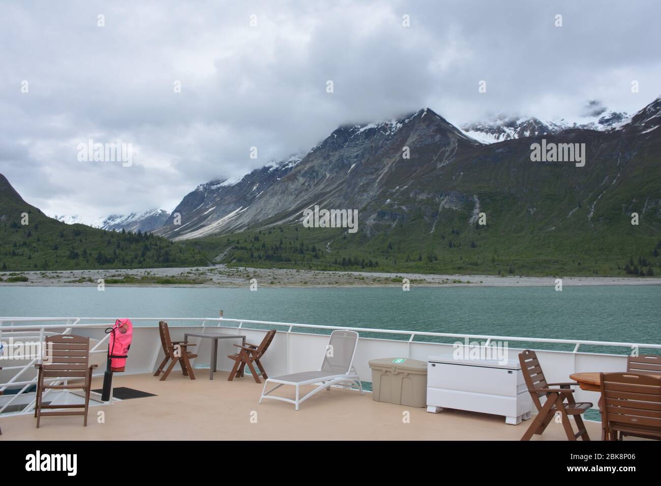The deck of a small cruise ship and views of fjords and mountains at ...