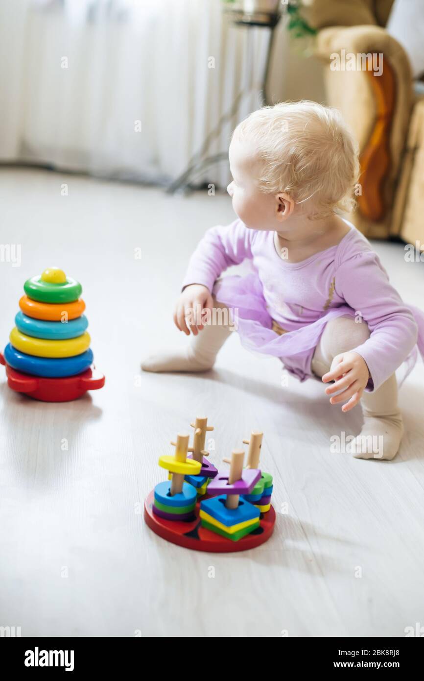 girl plays logical pyramid on floor in living room on sunny day ...