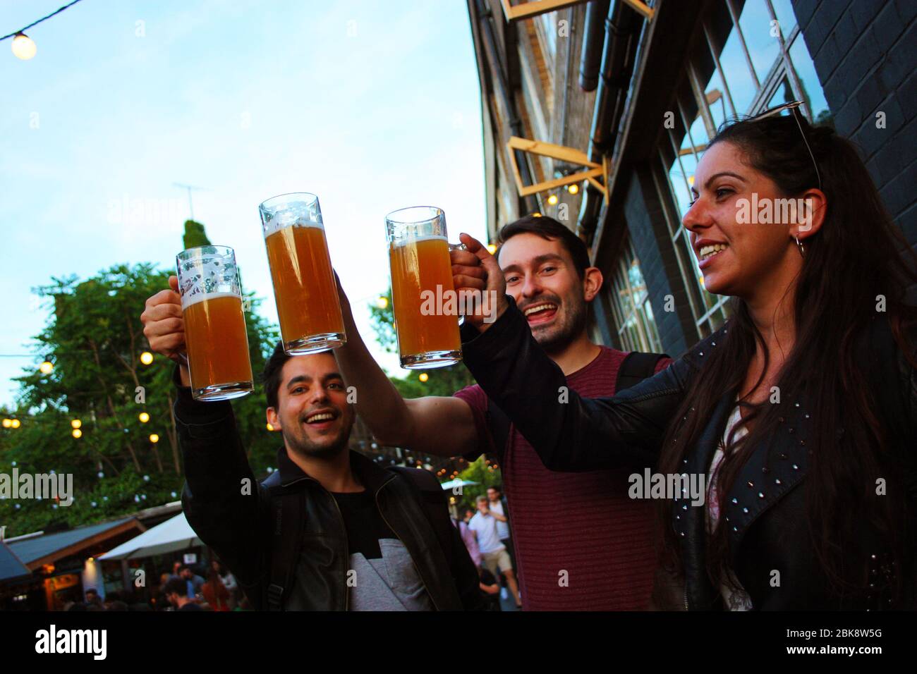 people at a party having fun together and drinking beer happily in ...