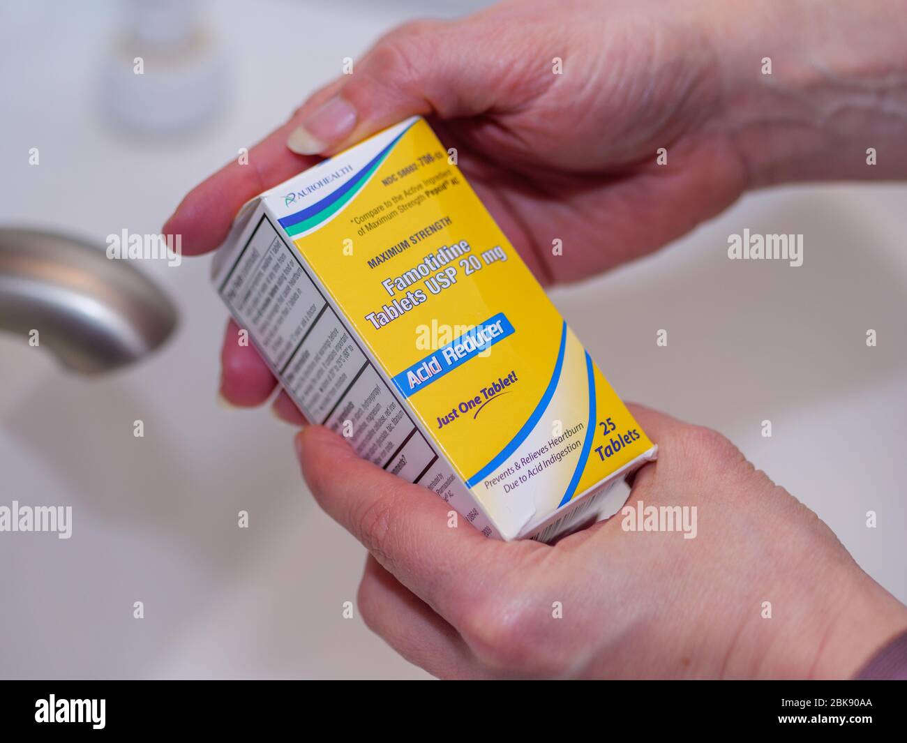 Woman's hands holding famotidine box 20mg tablets. The drug is ...