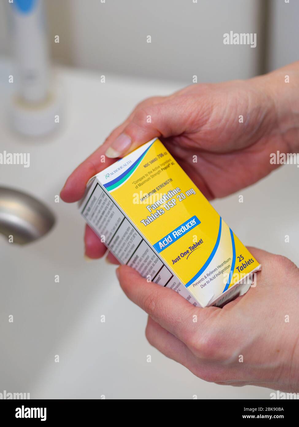 Woman's hands holding famotidine box 20mg tablets. The drug is ...