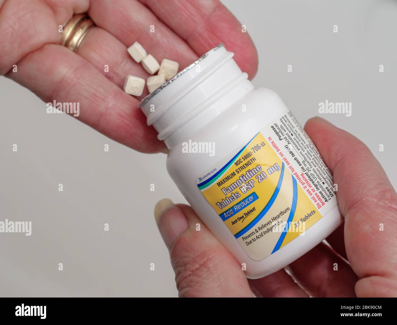 Woman s hands dispensing 20mg famotidine tablets from bottle. The drug is undergoing a trial as a treatment for COVID 19 Stock Photo Alamy
