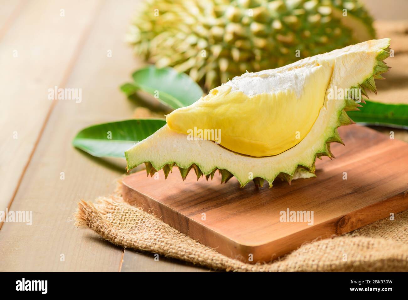 Fresh cut durian (monthong) on sack and old wood background, king of fruit from Thailand on ...