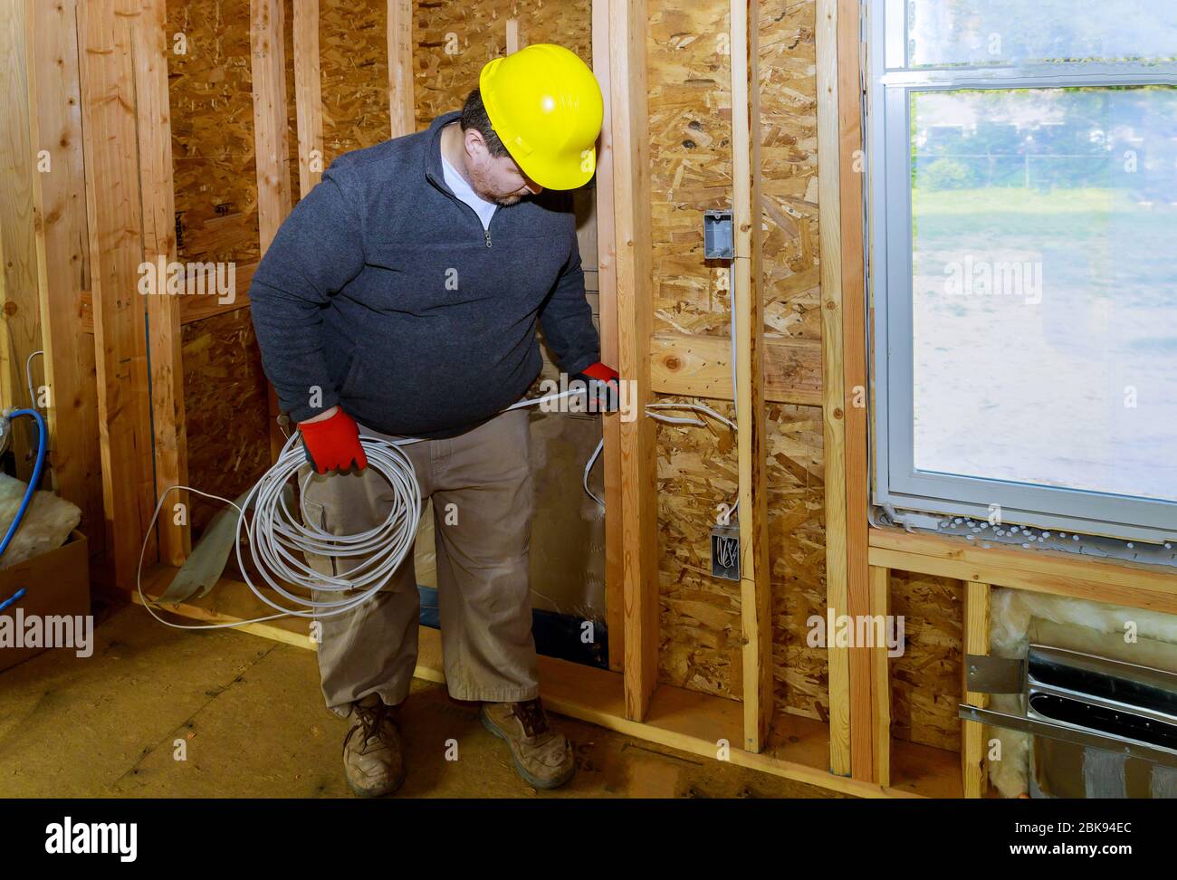 Electrician stripping wire installing wall socket in new house a ...