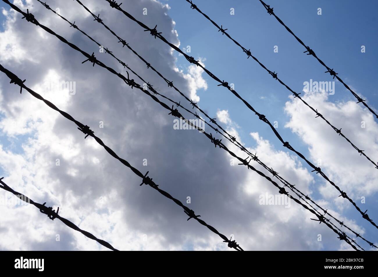 Barbed wire, sky in background - prison/ jail Stock Photo - Alamy