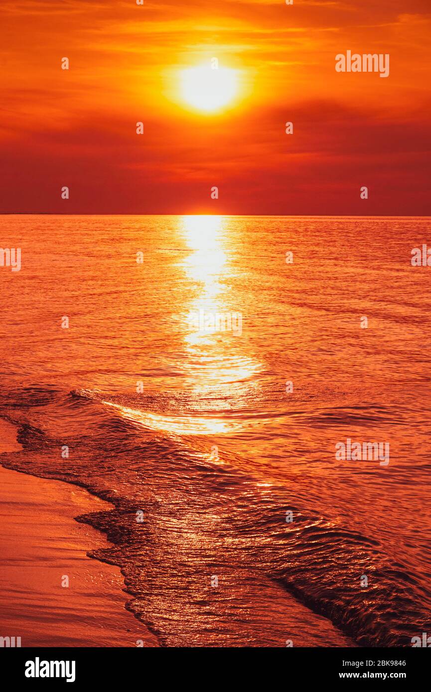Sunset - sun reflecting in sea/ ocean, shore Stock Photo - Alamy