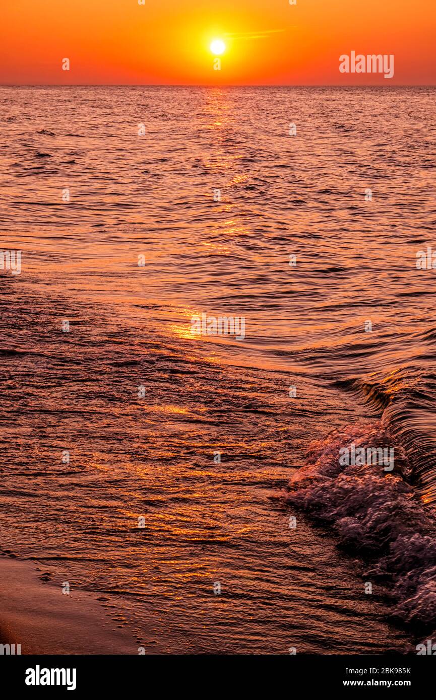 Sunset - sun reflecting in sea/ ocean, shore Stock Photo - Alamy
