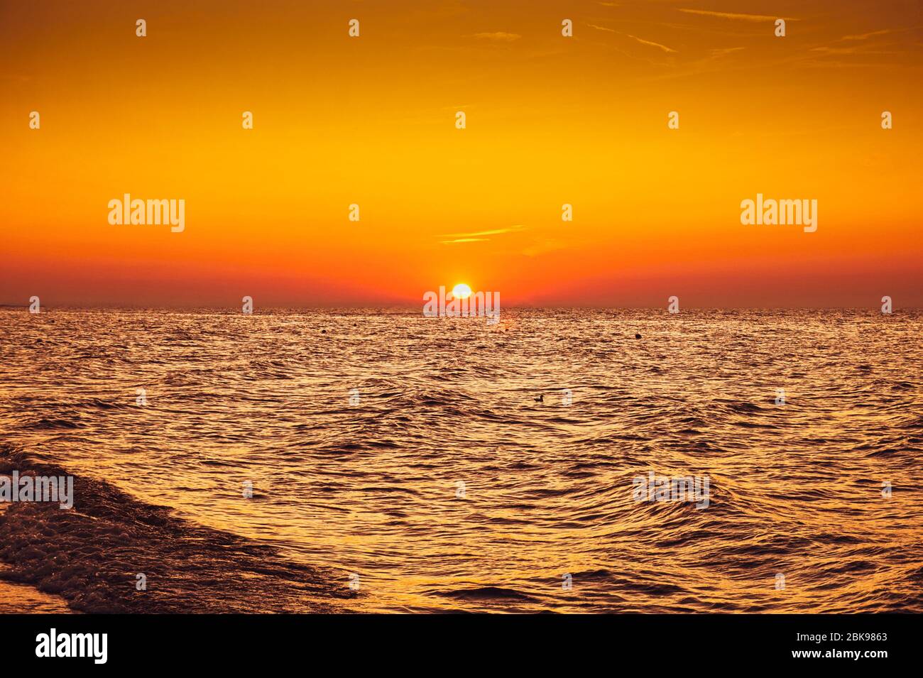 Sunset - sun reflecting in sea/ ocean, shore Stock Photo - Alamy