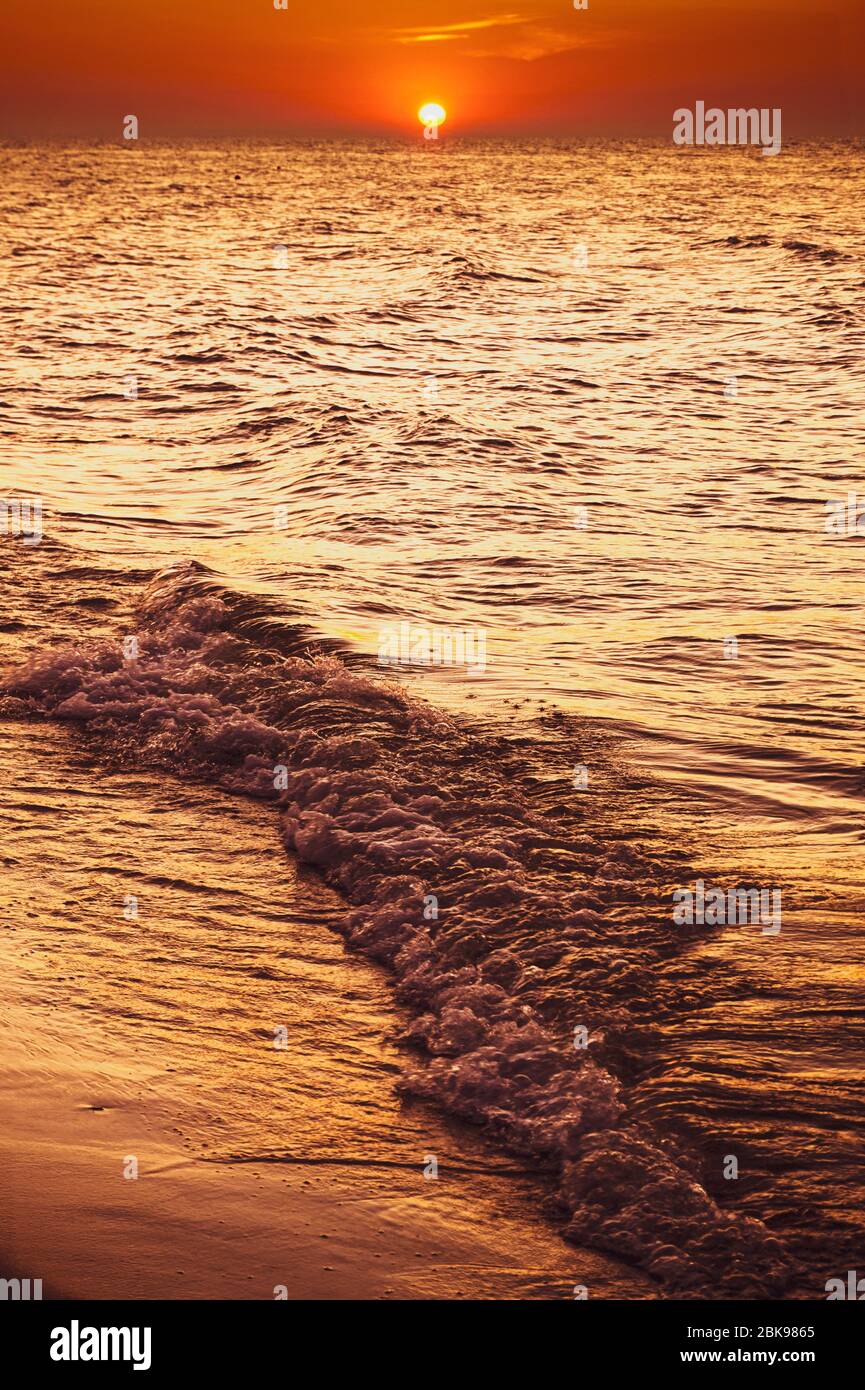 Sunset - sun reflecting in sea/ ocean, shore Stock Photo - Alamy