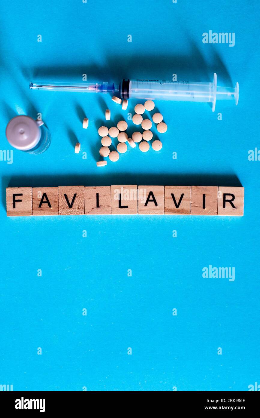 shot of tablets, glass bottle, syringe on blue and wooden blocks with ...