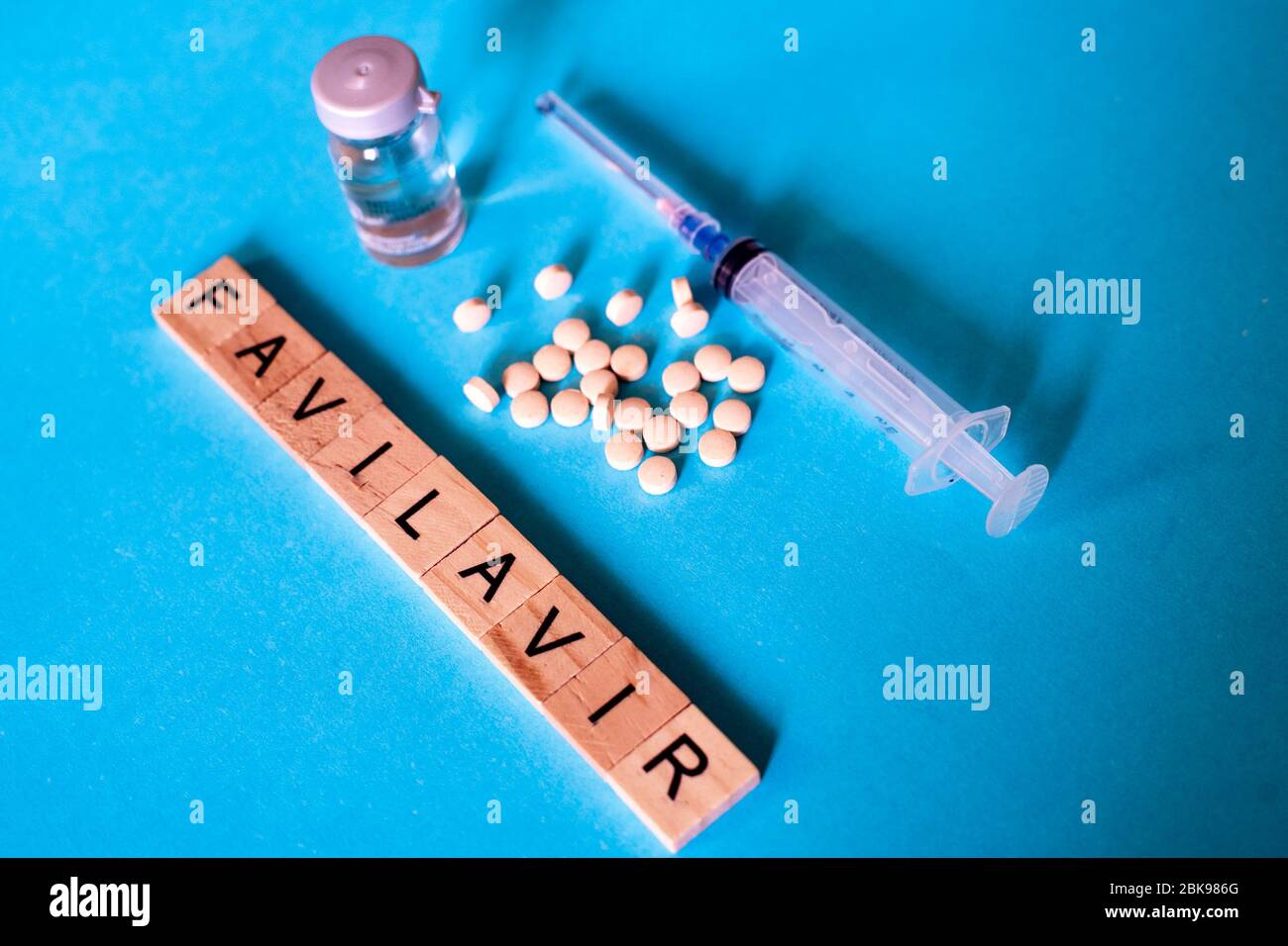 shot of tablets, glass bottle, syringe on blue and wooden blocks with ...