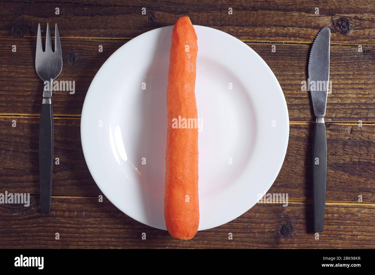 View from above on a plate with carrots, knife and fork on the table ...