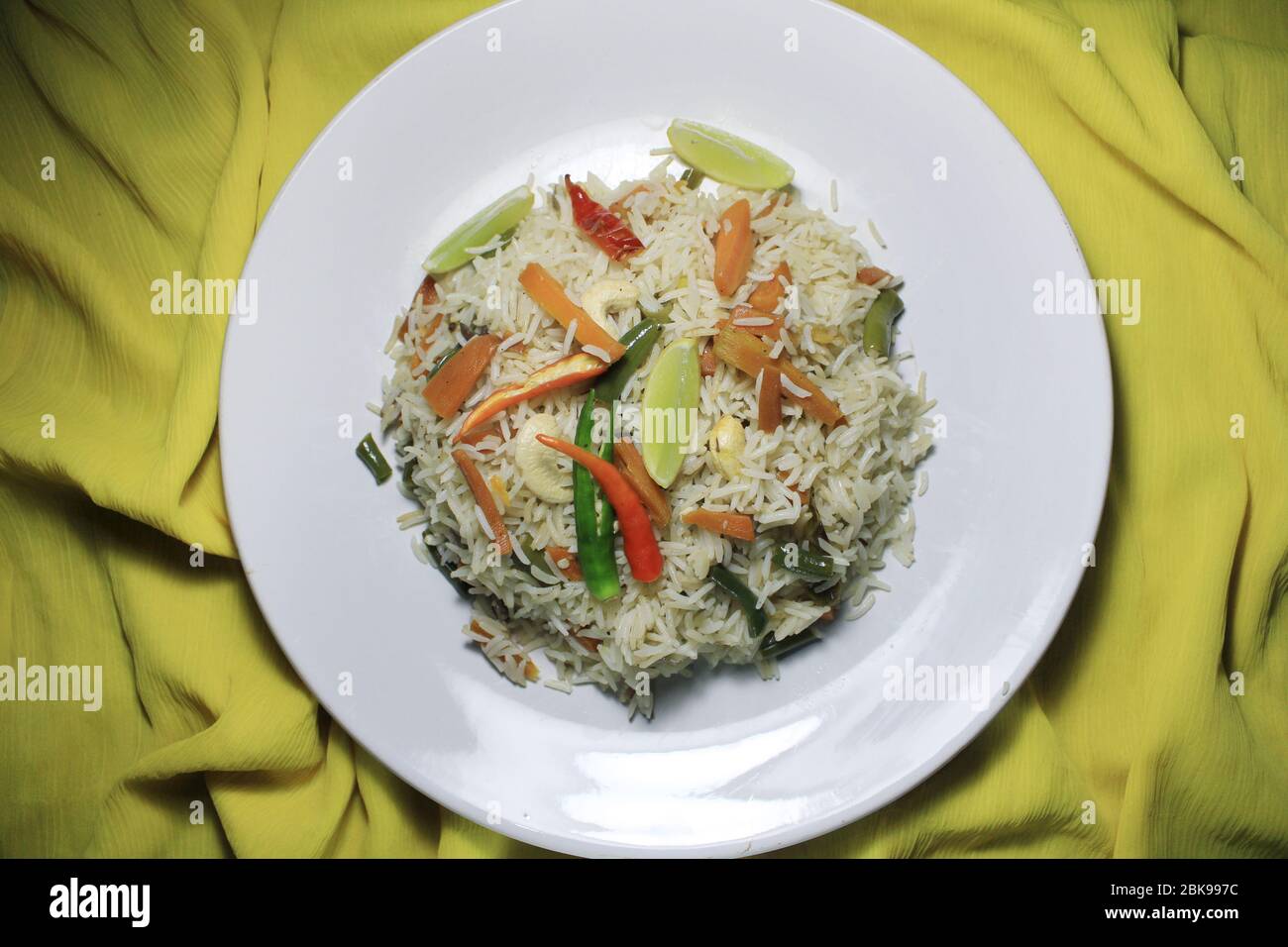 Vegetable fried rice on white plate with lemon and chili. Top view ...