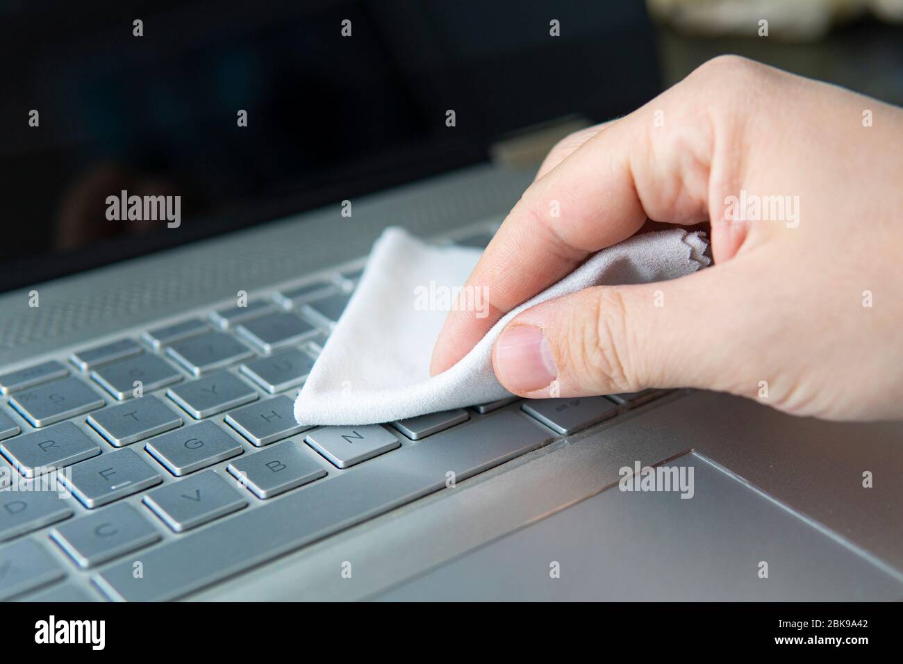 cleaning man with a rag of a computer keyboard. disinfecting measures ...