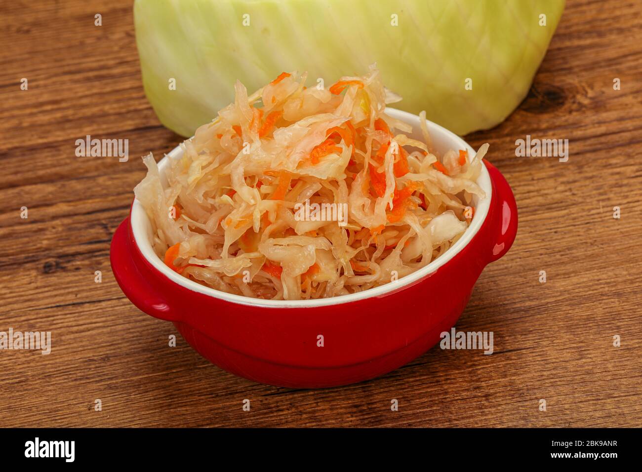 Pickled cabbage - sauerkraut in the bowl over wooden Stock Photo - Alamy