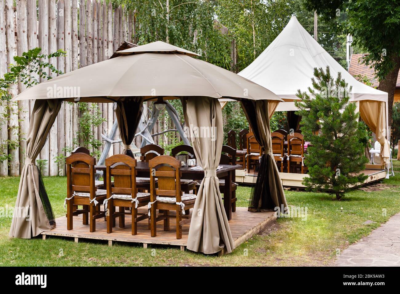 Two canvas tents with wooden tables and chairs. Vintage design of the ...