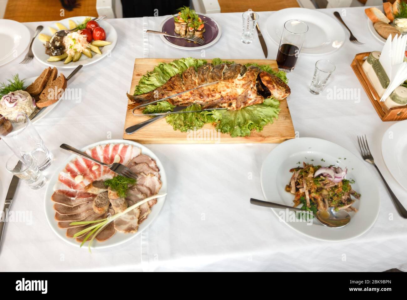 Fried fish and dishes on a banquet table in a restaurant, Follow depth ...