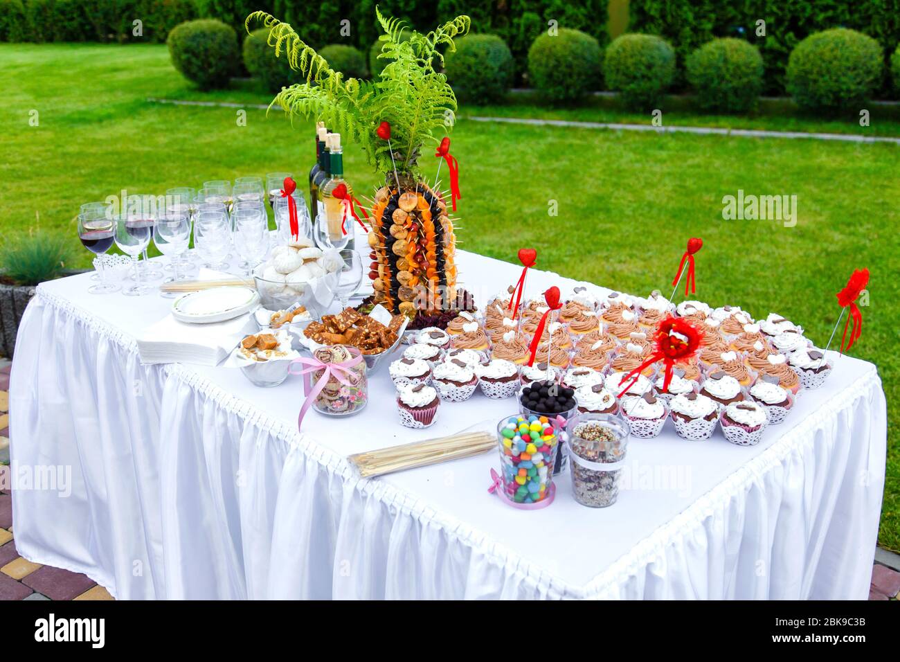 Muffins with hearts, sweets, fruits and vine on the banquet table Stock ...