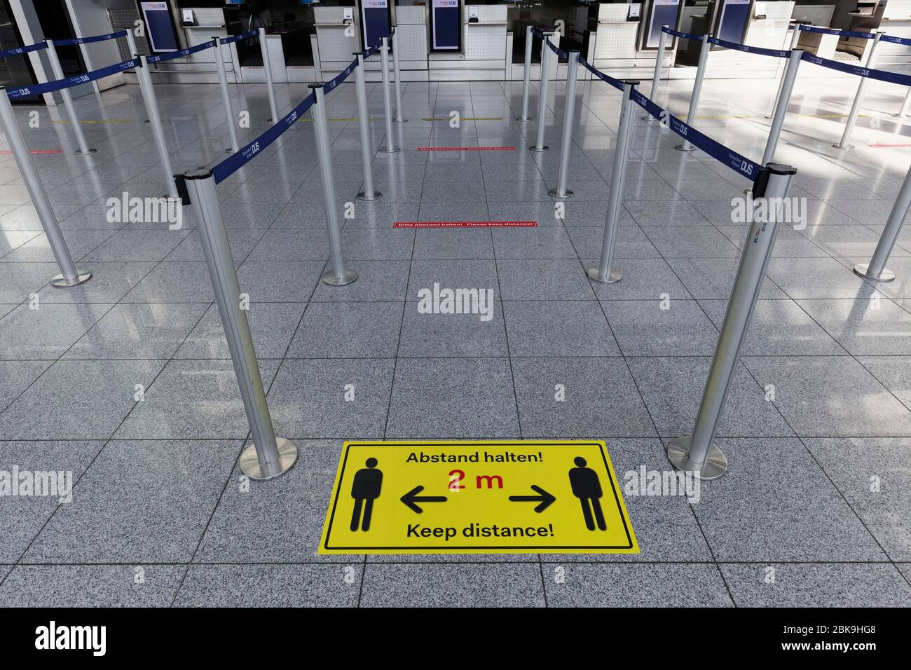 Sign with distance rule in front of the deserted baggage check, flight ...