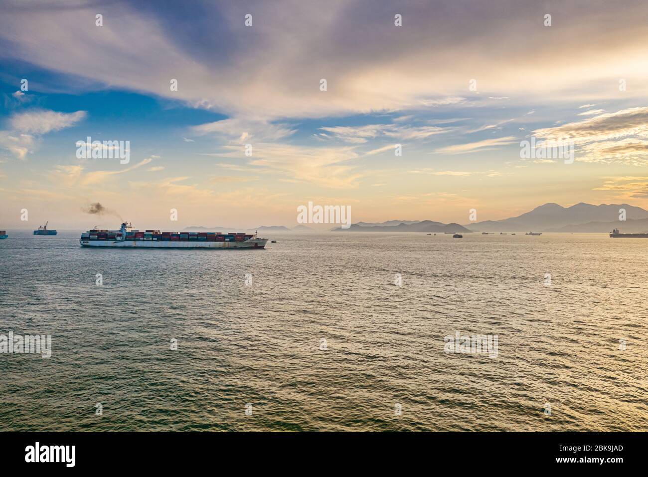 Container ships pass in and out Victoria Harbour at dusk Stock Photo ...