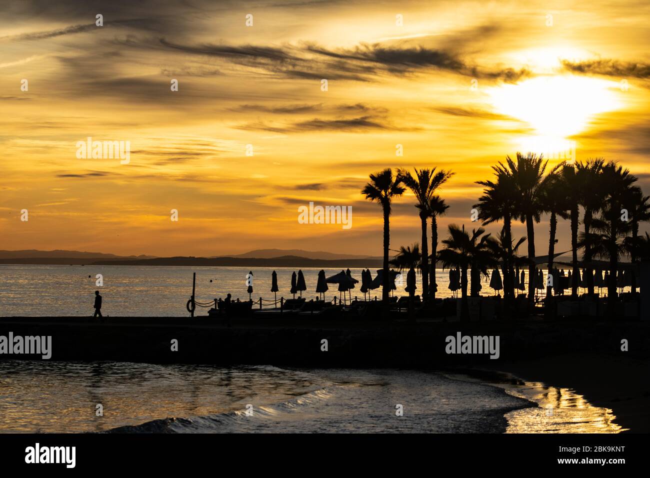 a beautiful golden sunset along the coast at one of the many beaches of ...