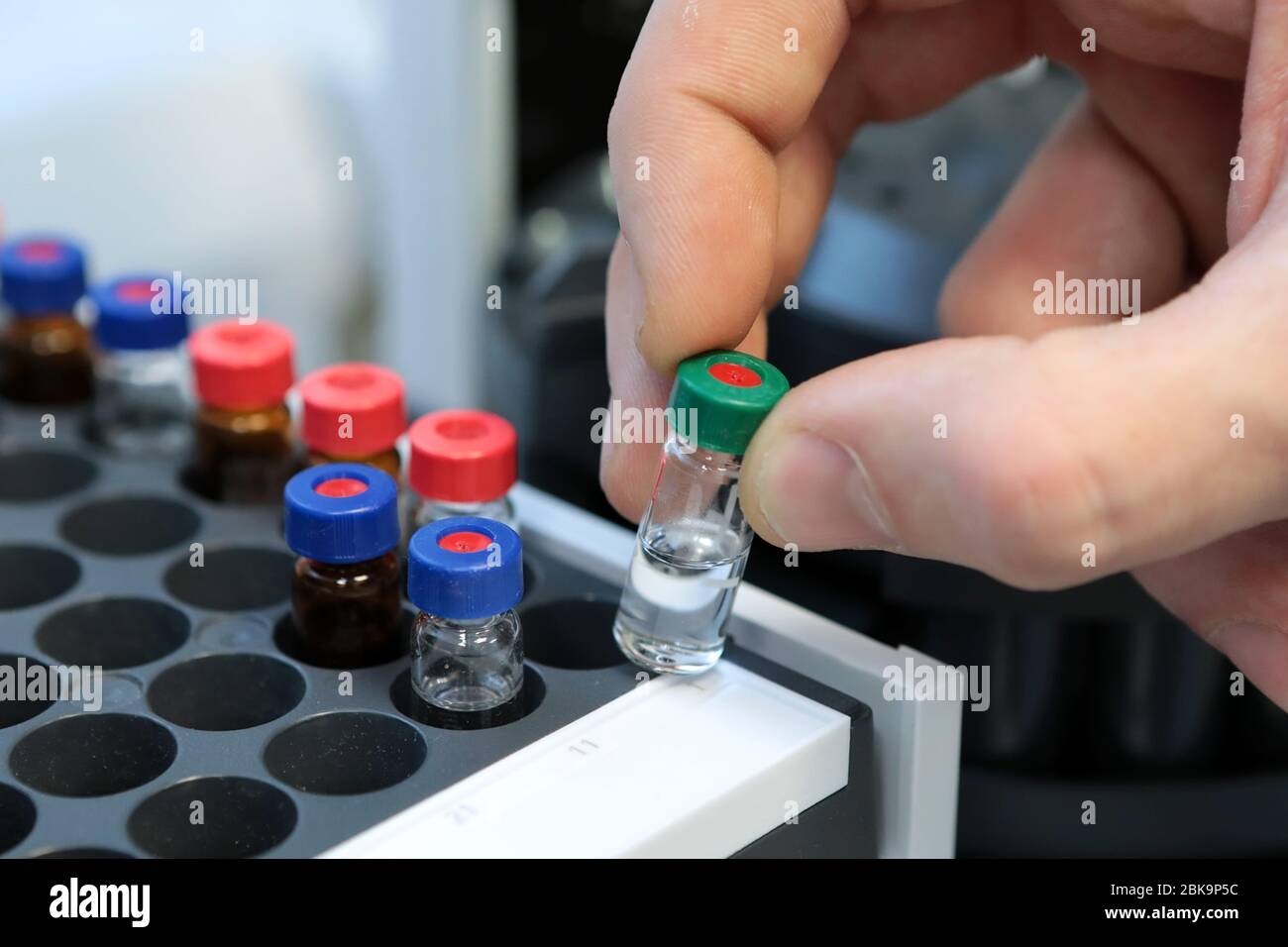 Scientist holds a chemical sample bottle. Doctor hand in medical glove ...