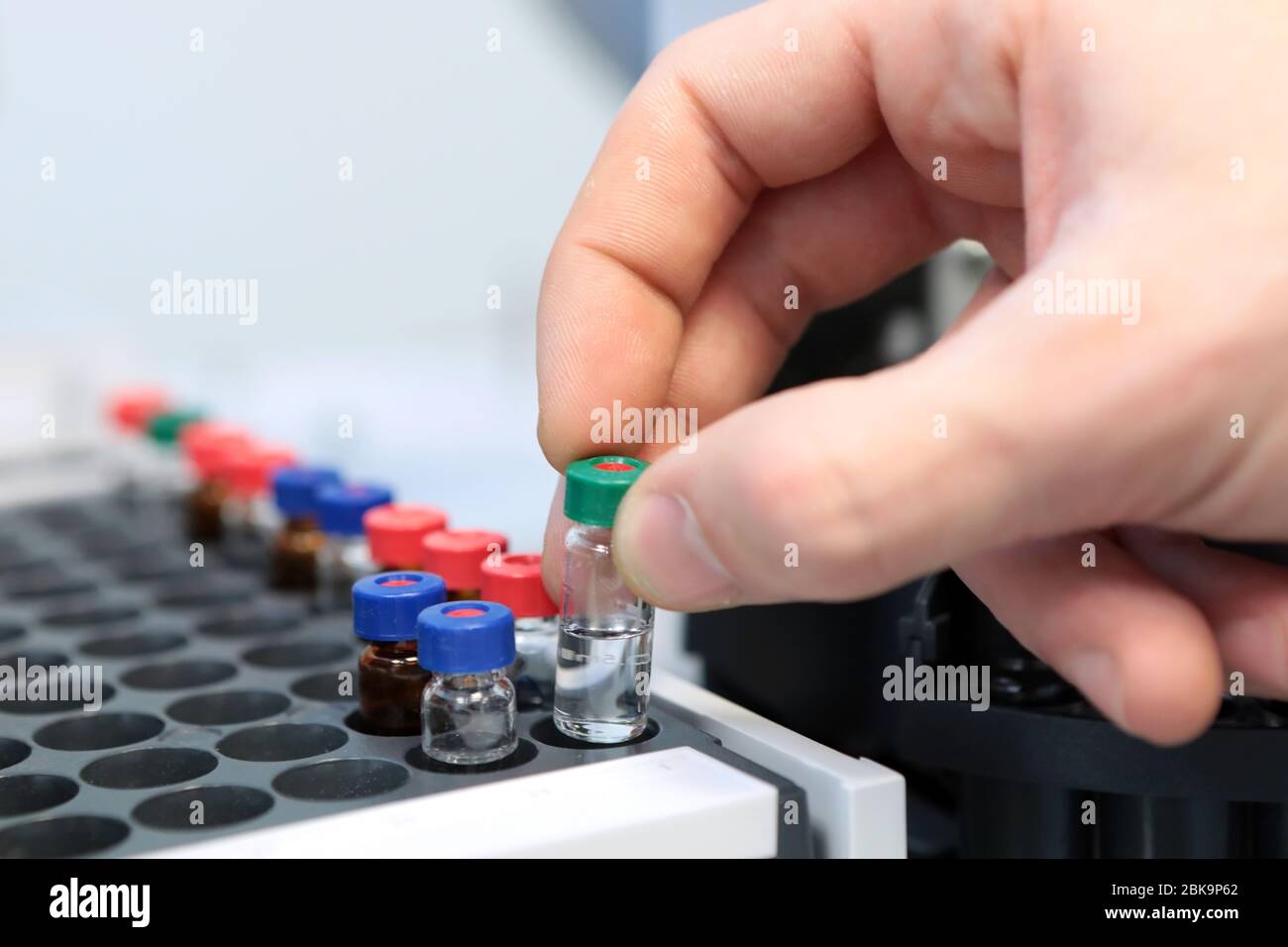 Scientist holds a chemical sample bottle. Doctor hand in medical glove ...