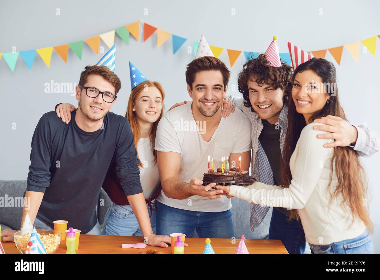Happy Birthday party. A group of friends with a cake wishes the man a ...