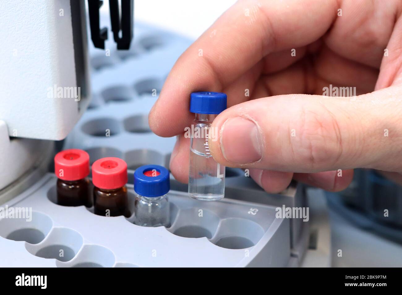 Scientist holds a chemical sample bottle. Doctor hand in medical glove ...