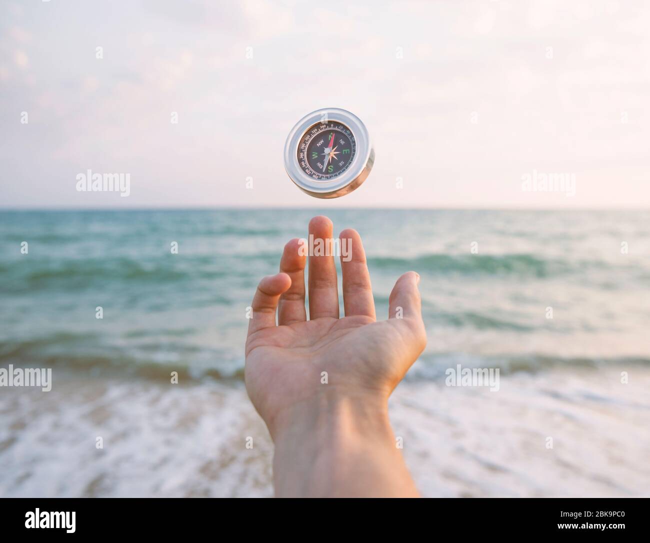 Hand with Compass with sea background Stock Photo - Alamy