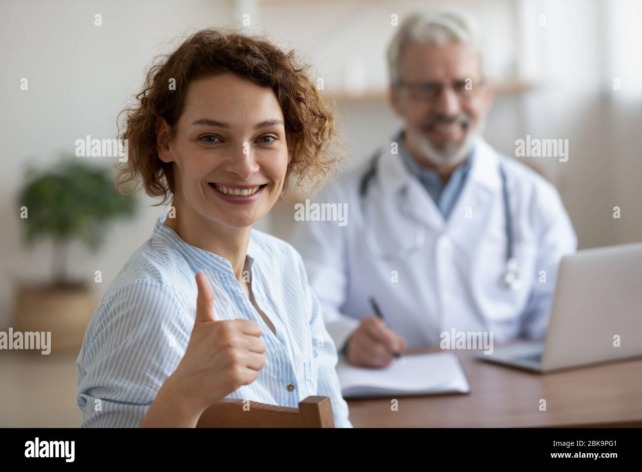 Satisfied healthy woman patient looking at camera showing thumbs up ...