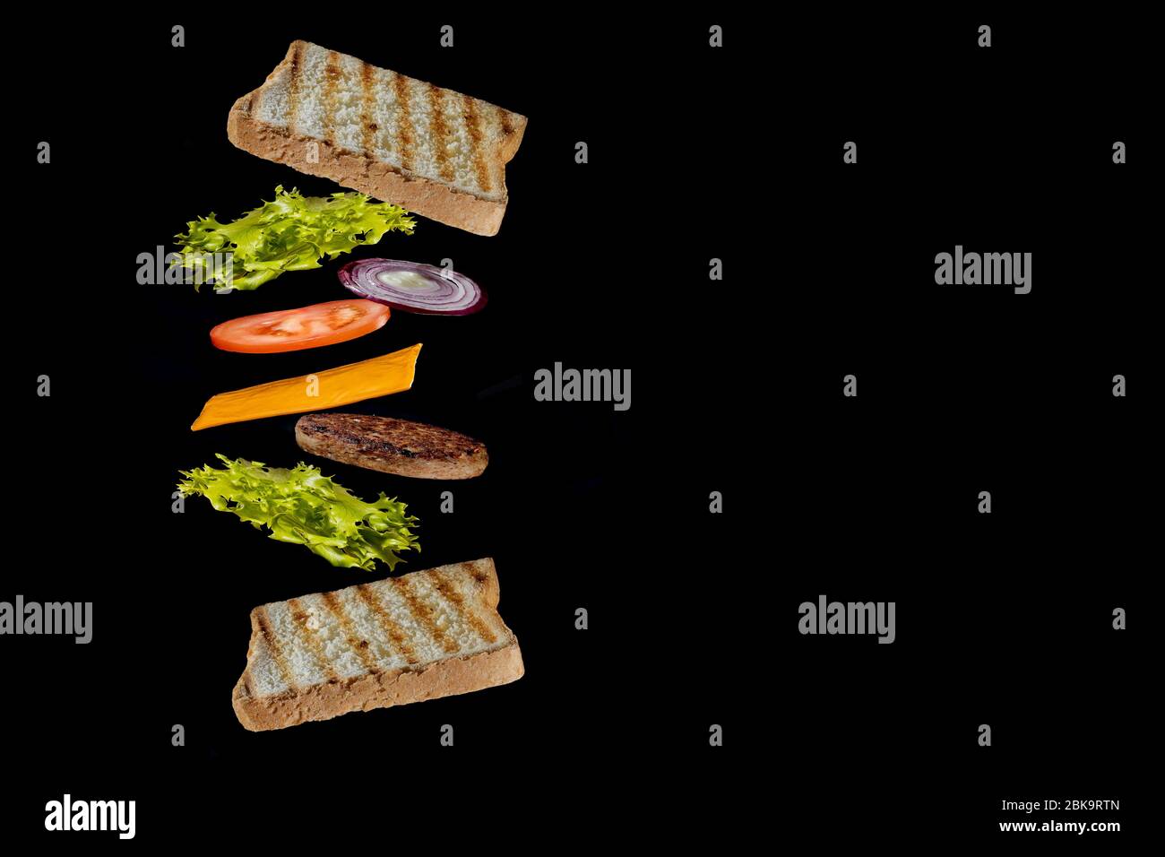 Fresh sandwich with flying ingredients isolated on black background ...