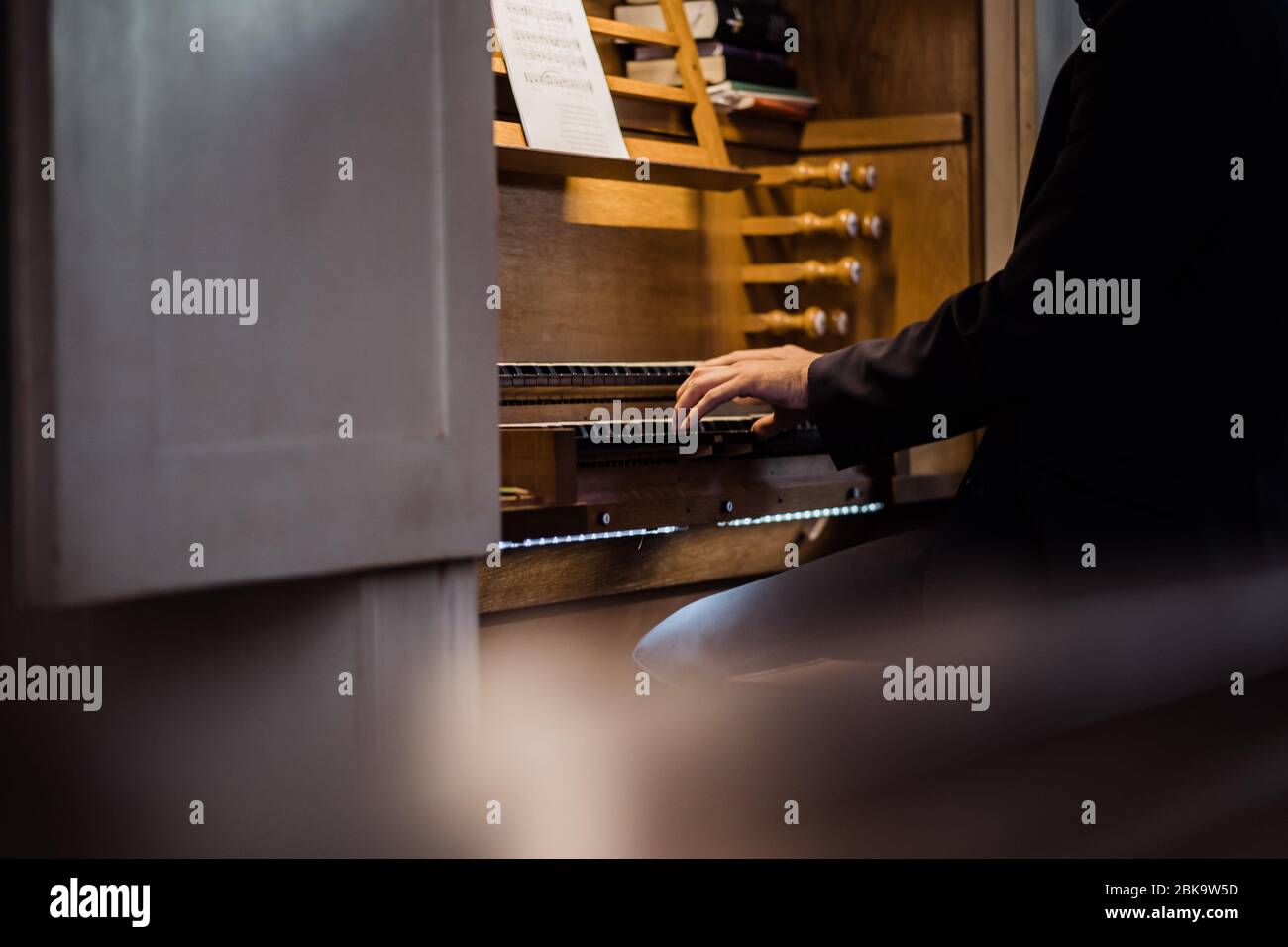photo of a man playing piano in a church Stock Photo - Alamy