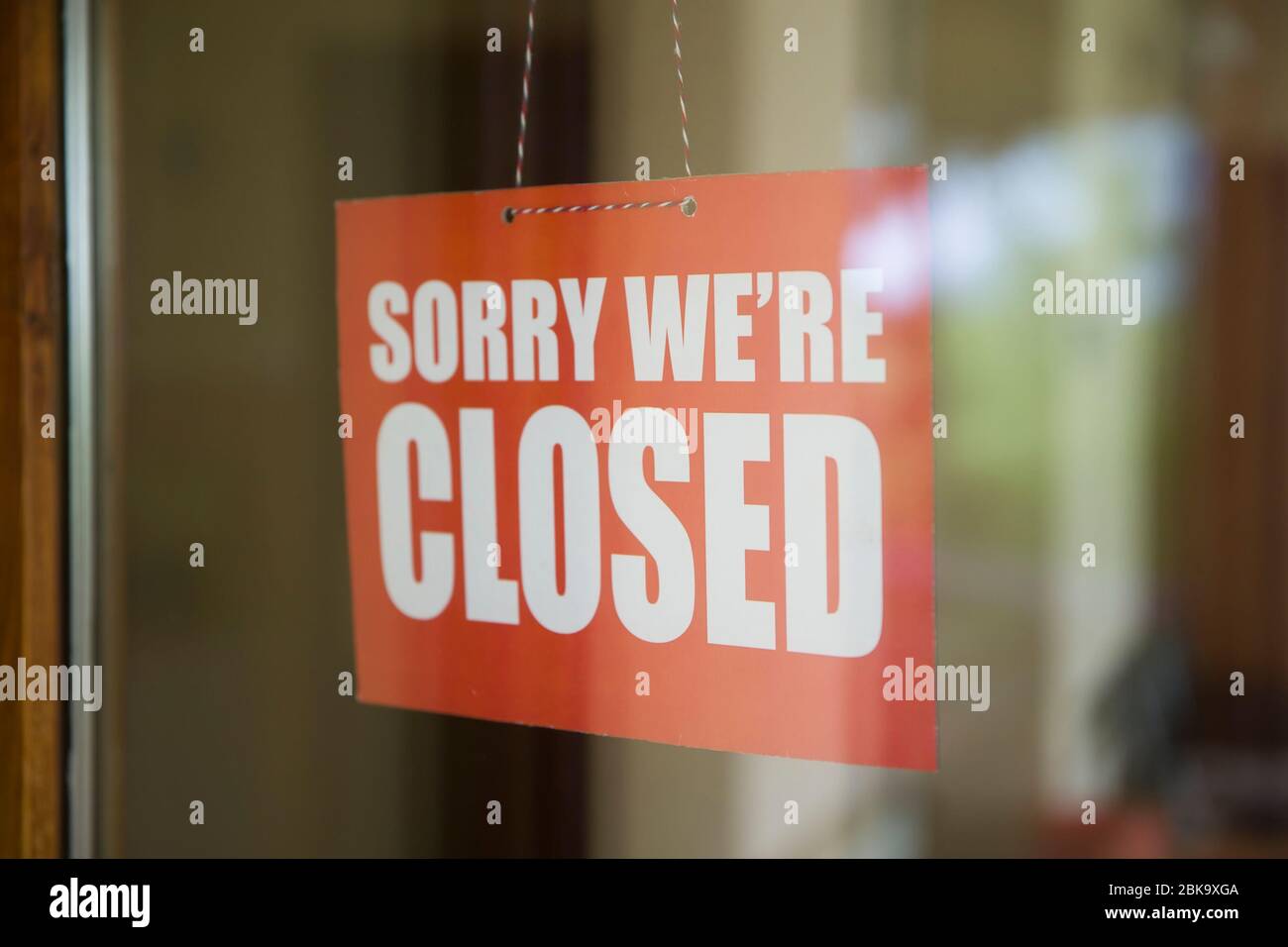 Closed sign board hanging on the glass door of cafe or small store ...