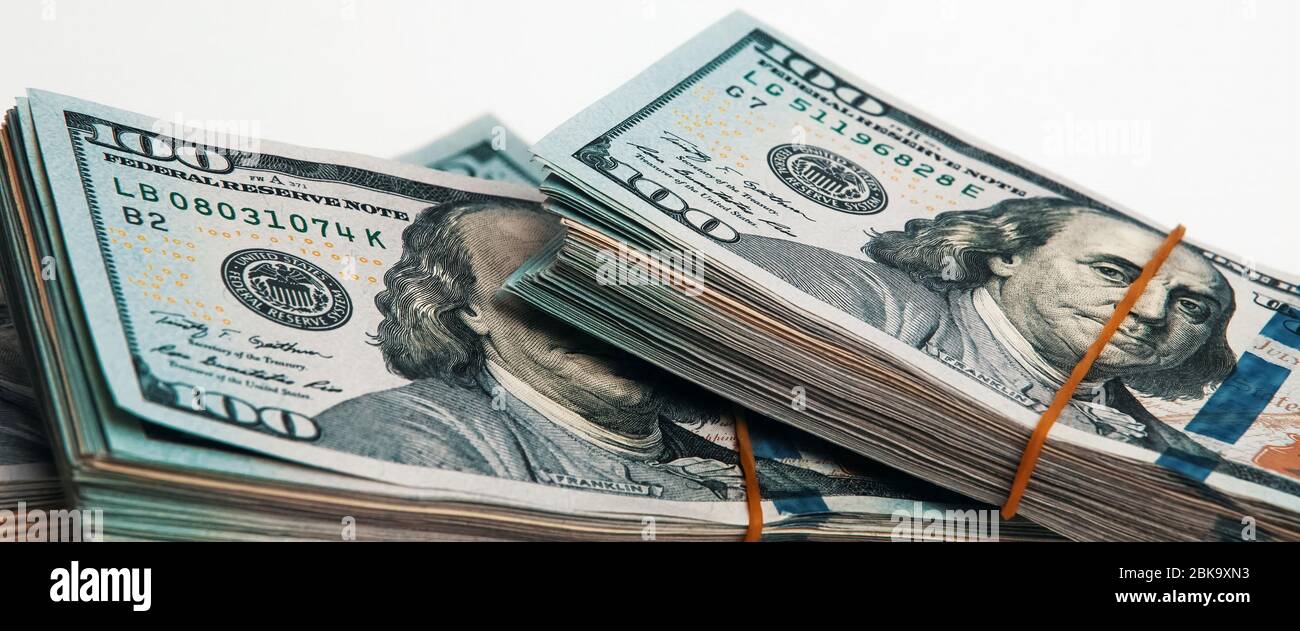 Isolated bundle of dollars. A large stack of hundred-dollar bills lies ...