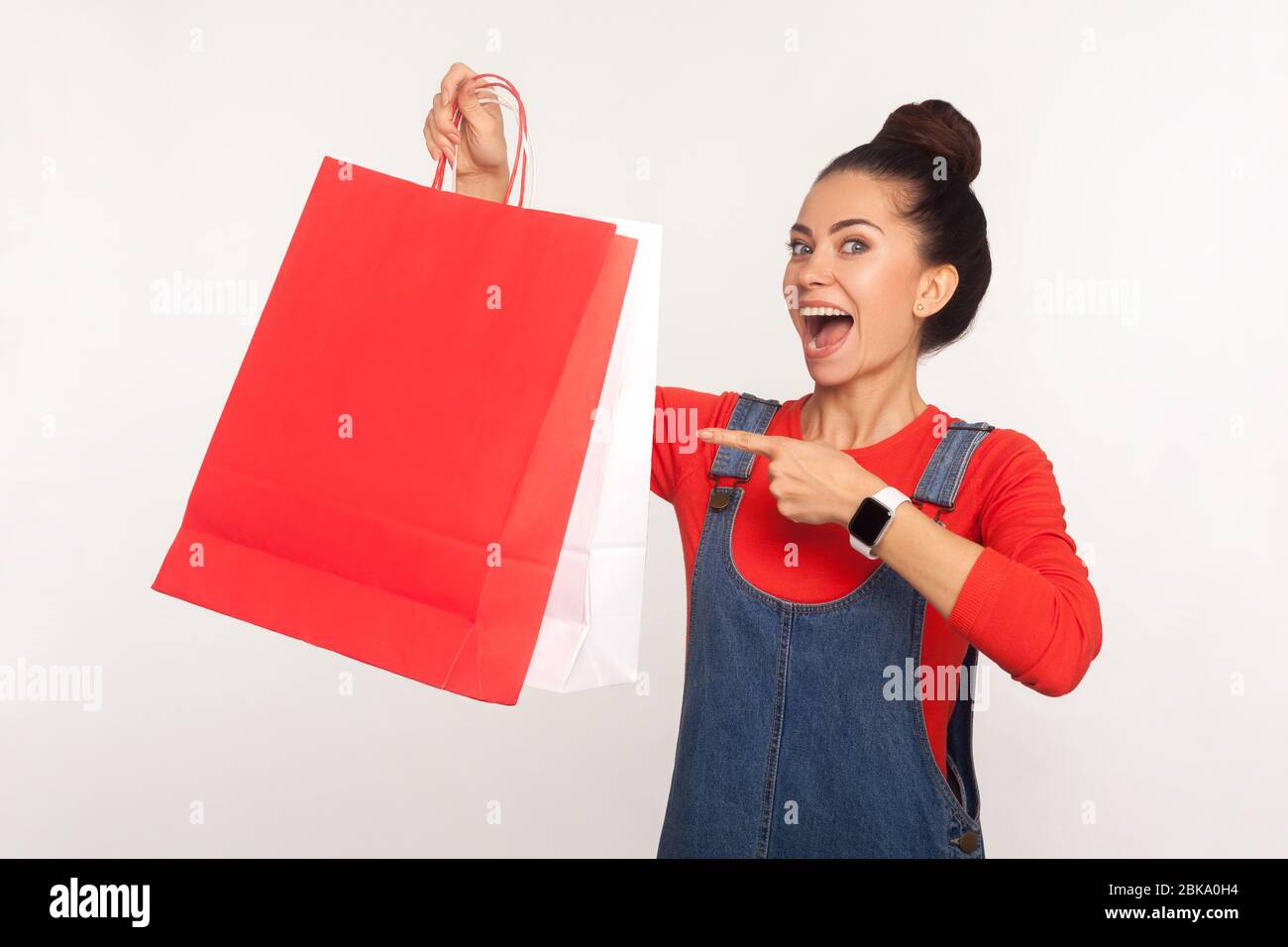 Portrait of amazed shopper boasting purchase. Surprised pretty girl ...