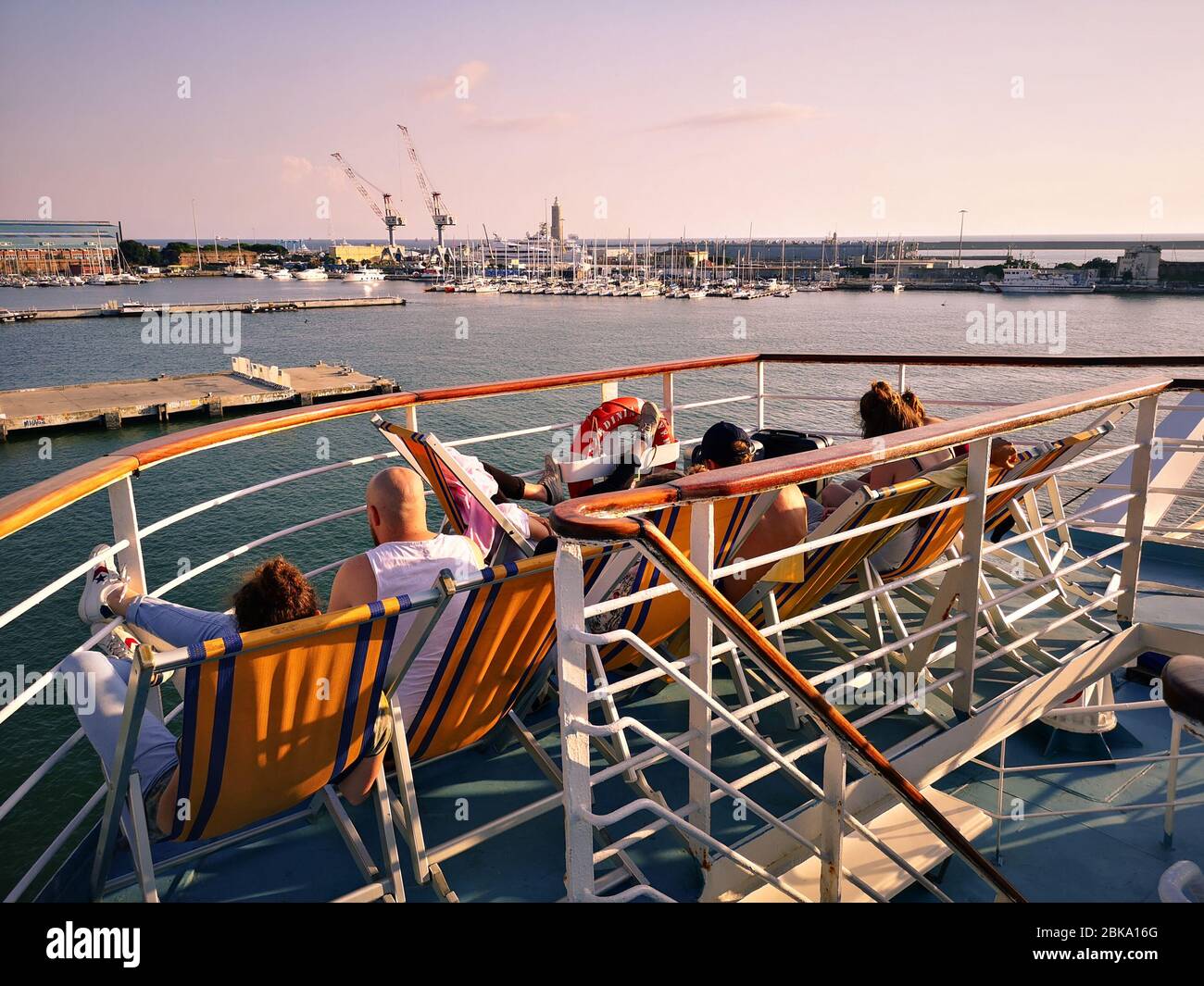 Passengers of a ferry relax on deck chairs while going on holiday Stock ...