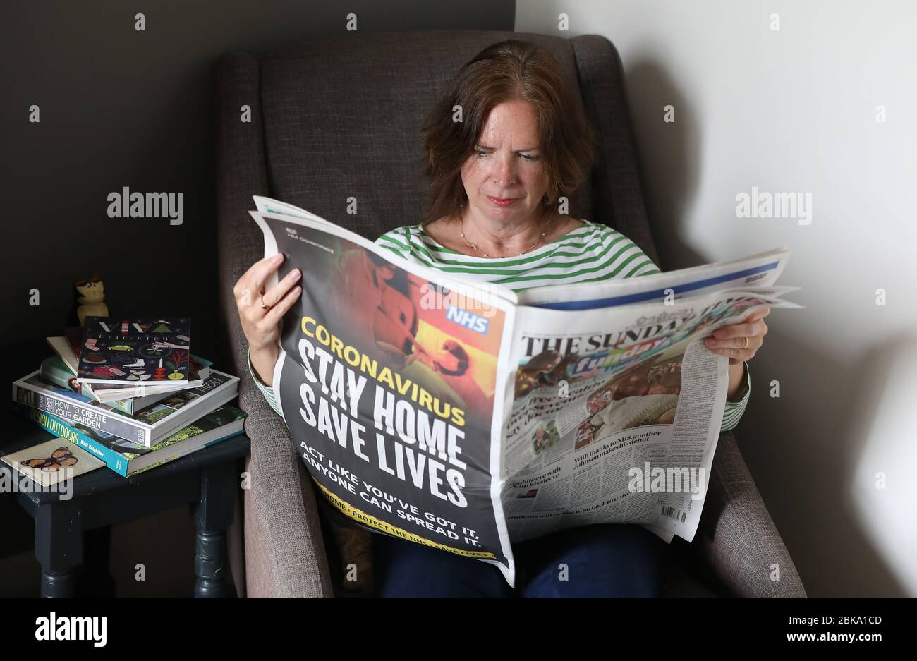 A woman reading the Sunday Times Newspaper at home during Lockdown due ...