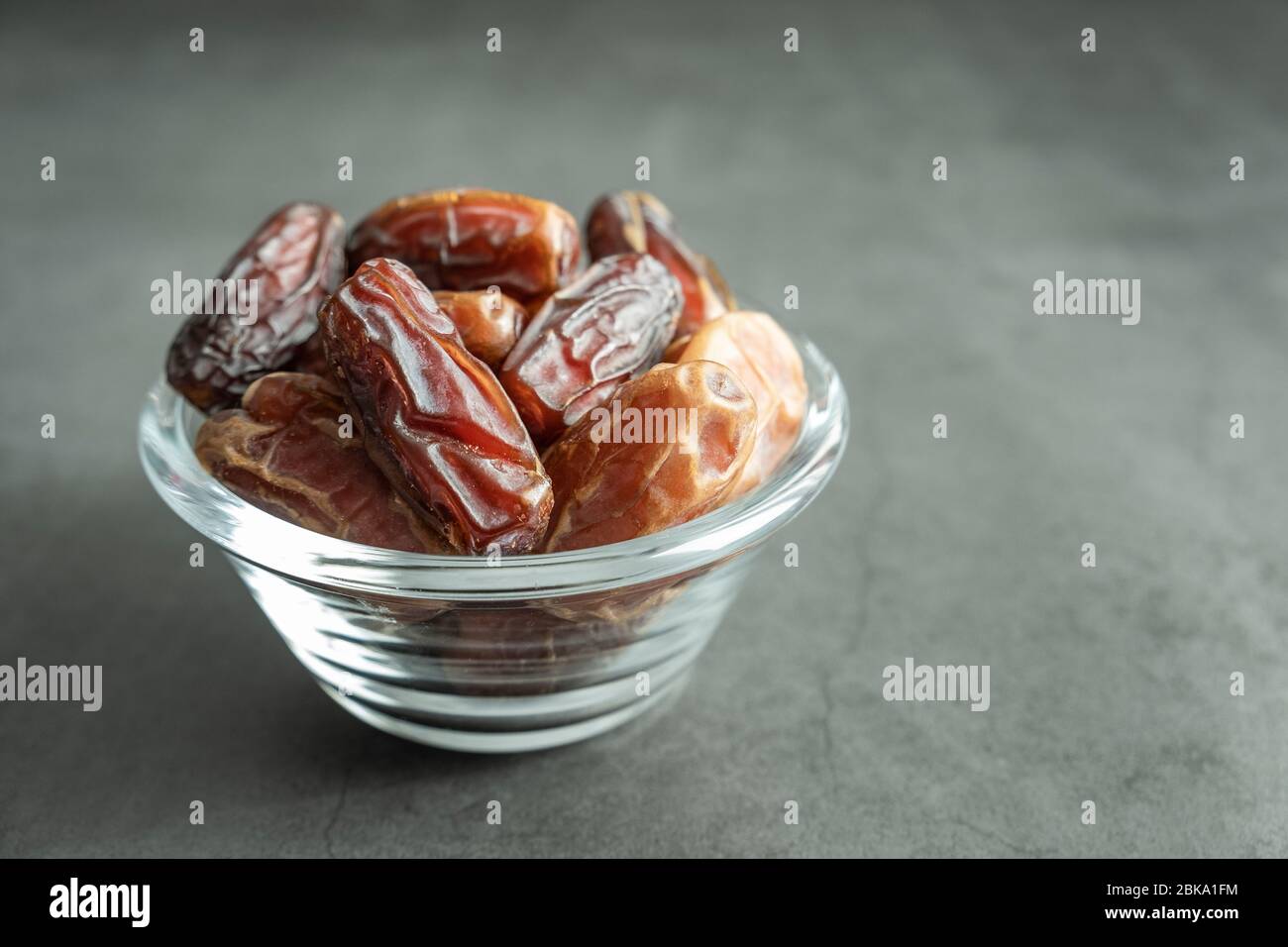 Raw date fruit ready to eat in glass bowl on concrete background ...