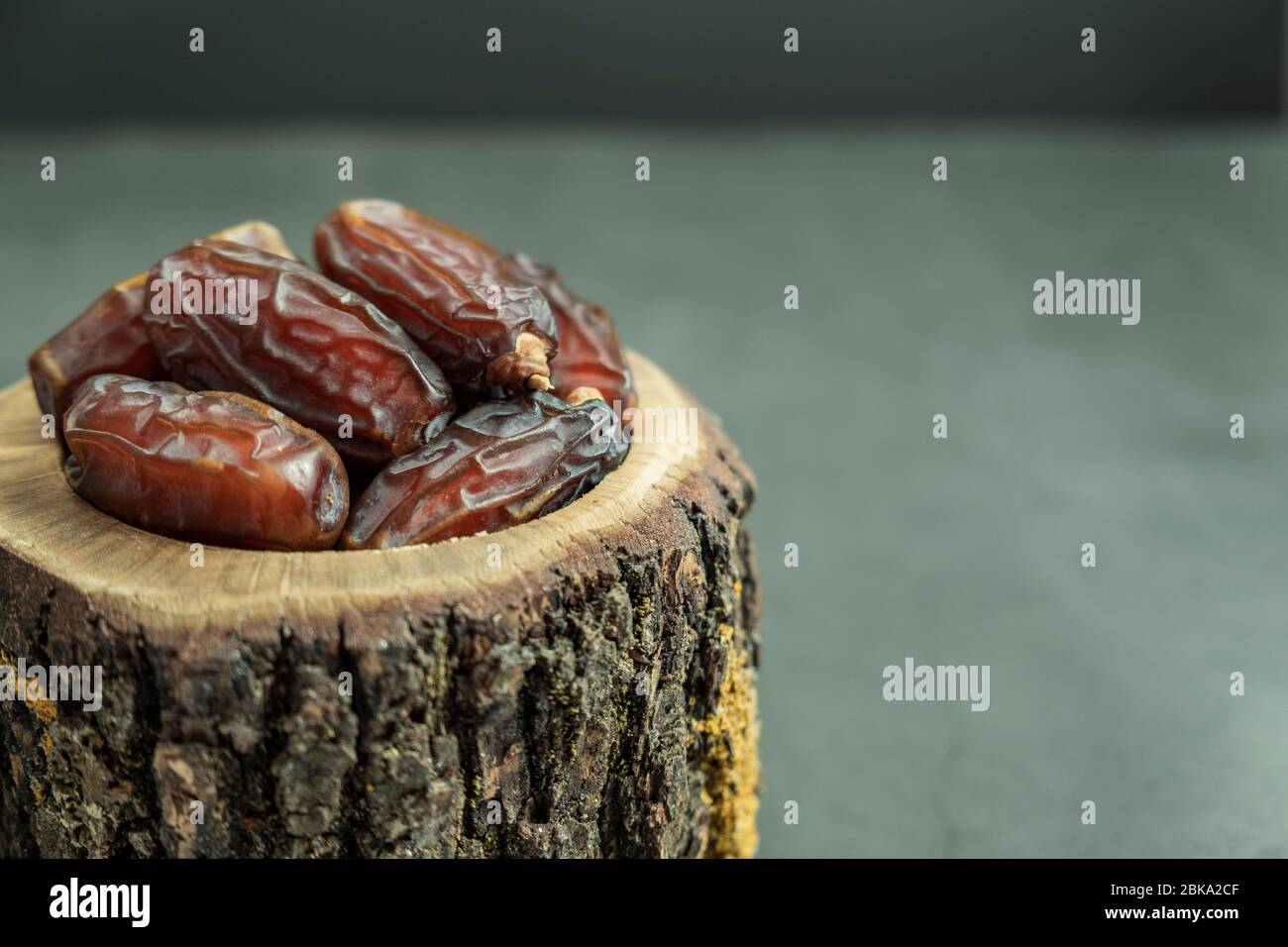 Raw date fruit ready to eat in wooden bowl on concrete background ...