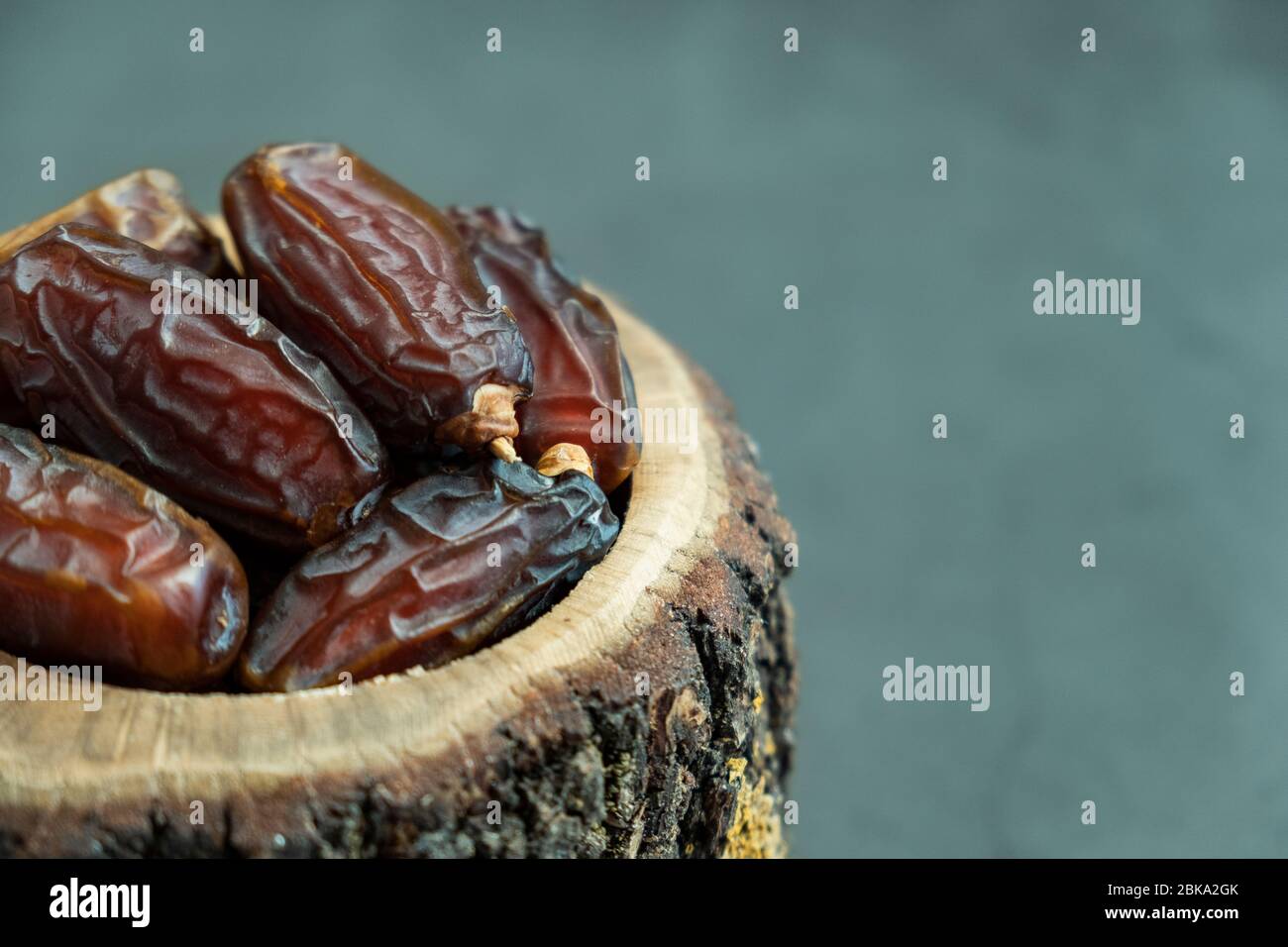 Raw date fruit ready to eat in wooden bowl on concrete background ...