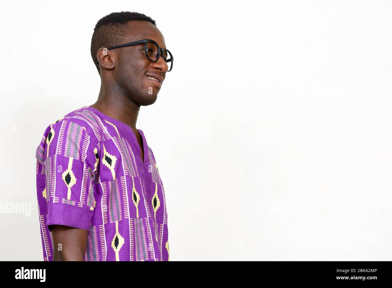 Profile view of happy young African man in traditional clothing smiling ...
