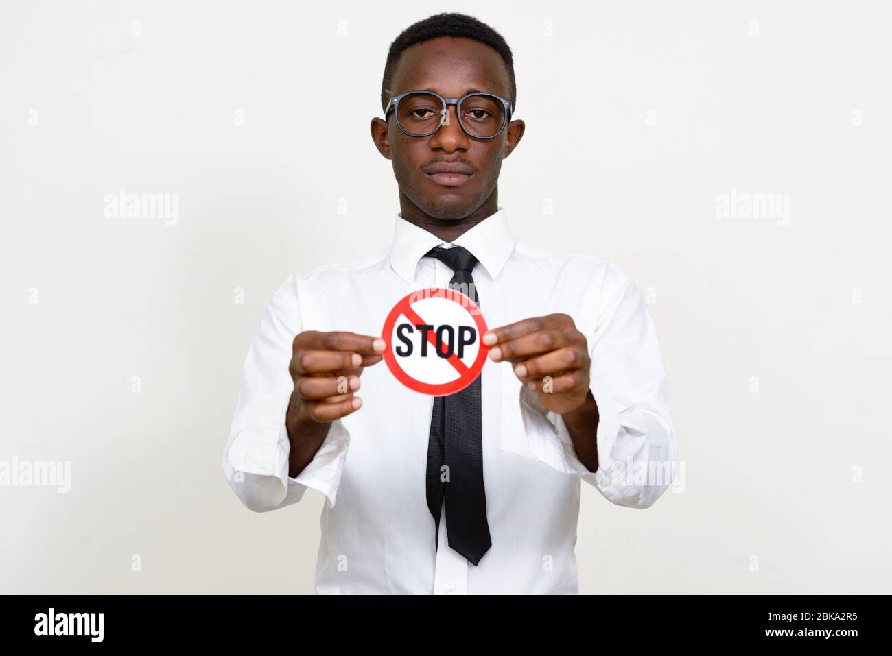 Portrait of young African businessman holding stop sign Stock Photo - Alamy