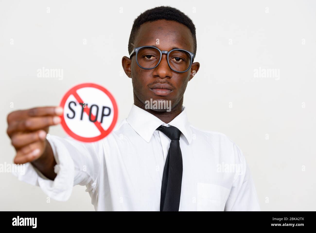 Face of young African businessman holding stop sign Stock Photo - Alamy