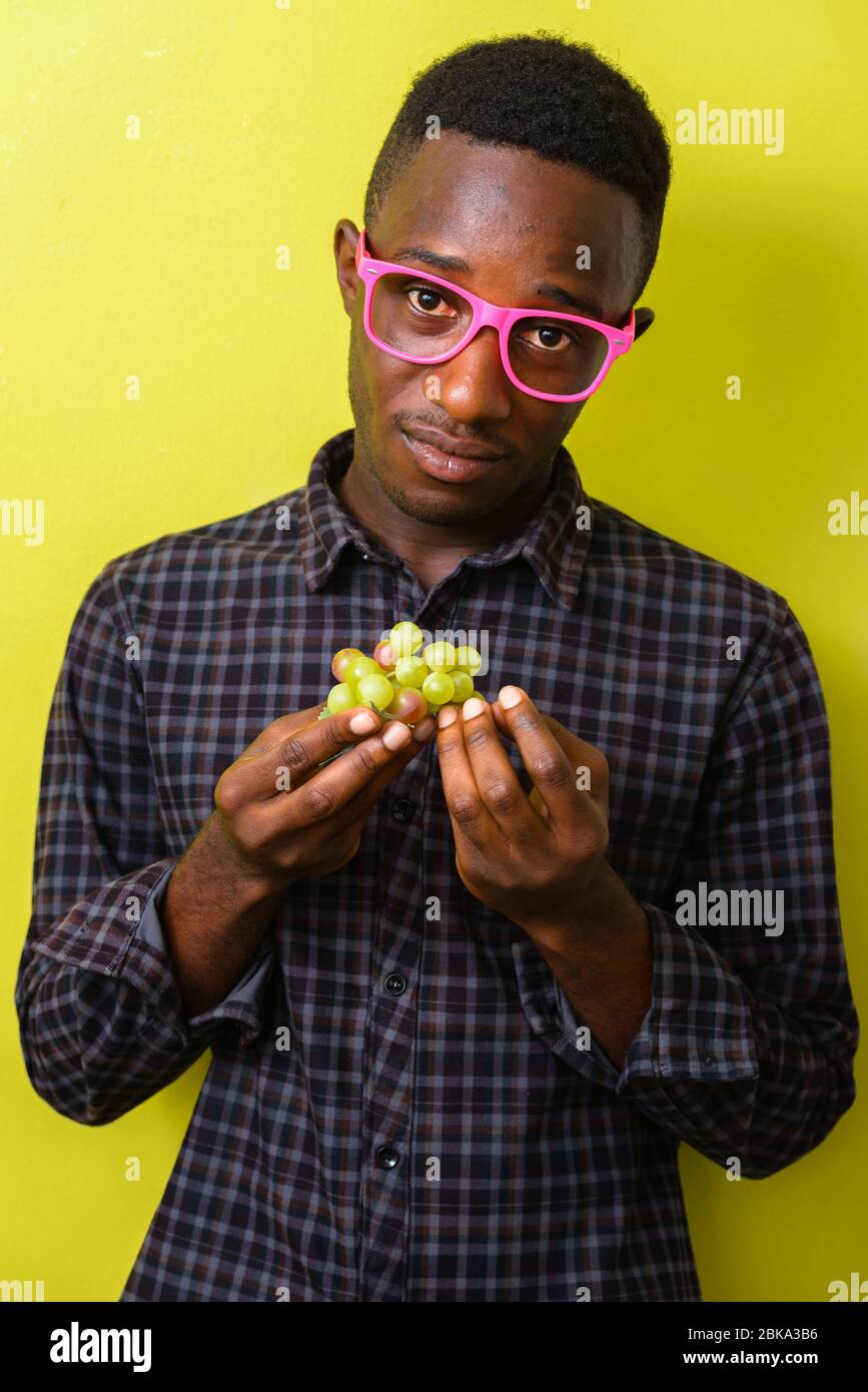 Portrait of young African hipster man eating grapes Stock Photo - Alamy