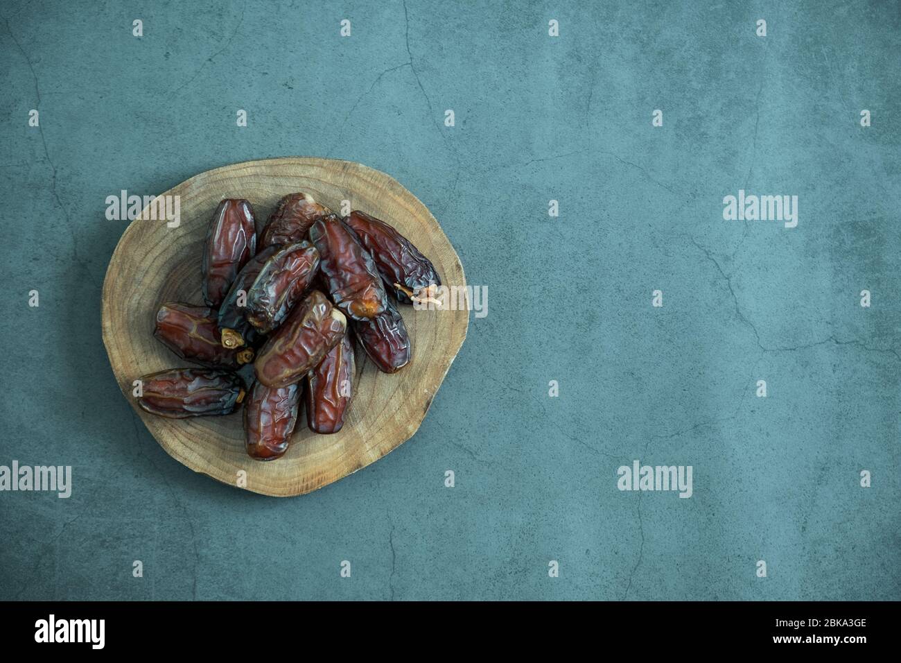 Raw date fruit ready to eat in wooden platter on concrete background ...