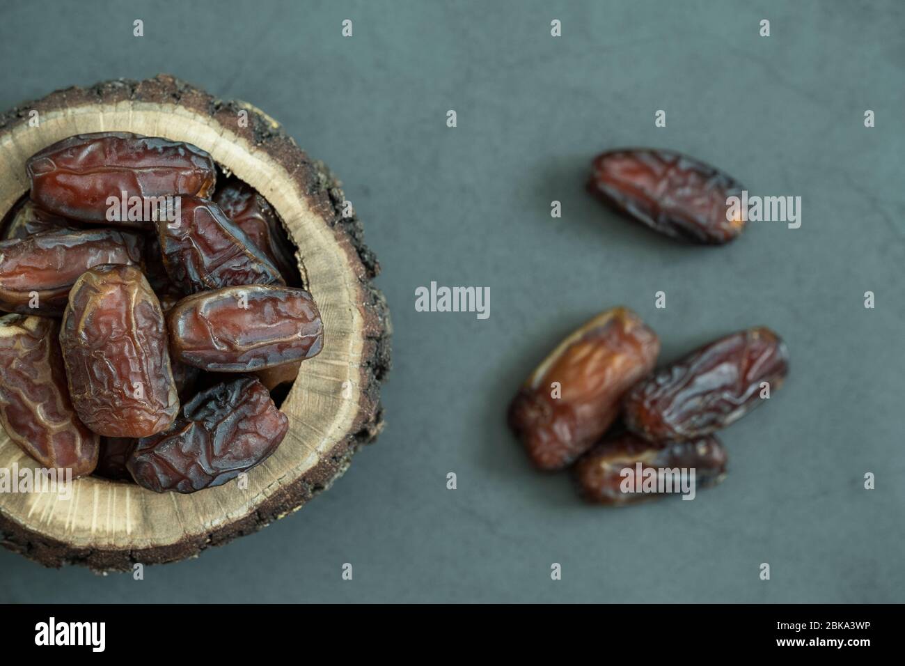 Raw date fruit ready to eat in wooden bowl on concrete background ...