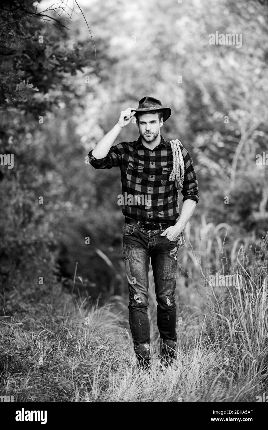 Hes a cowboy aint he. man checkered shirt on ranch. cowboy with lasso ...