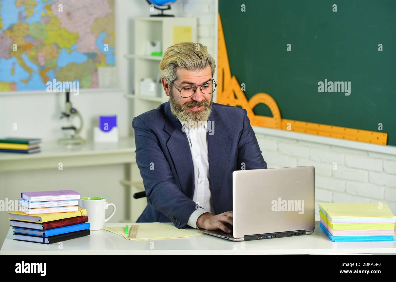 After classes. Man work school teacher sit in classroom. Degree ...